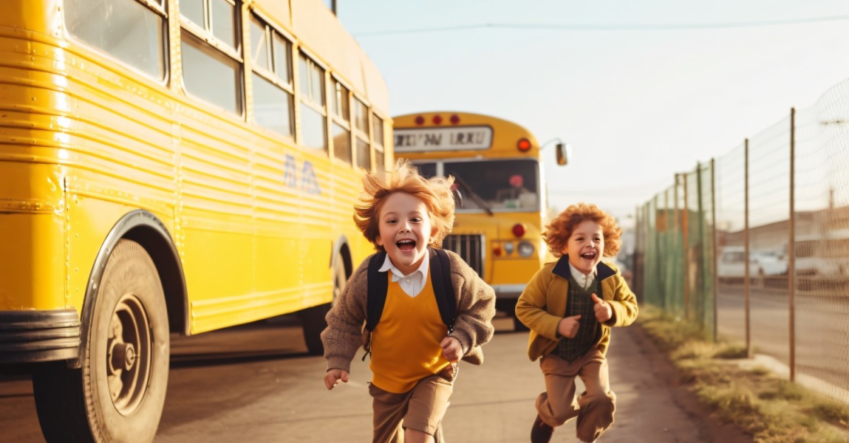 Kids running towards school, yellow bus behind the seen 297