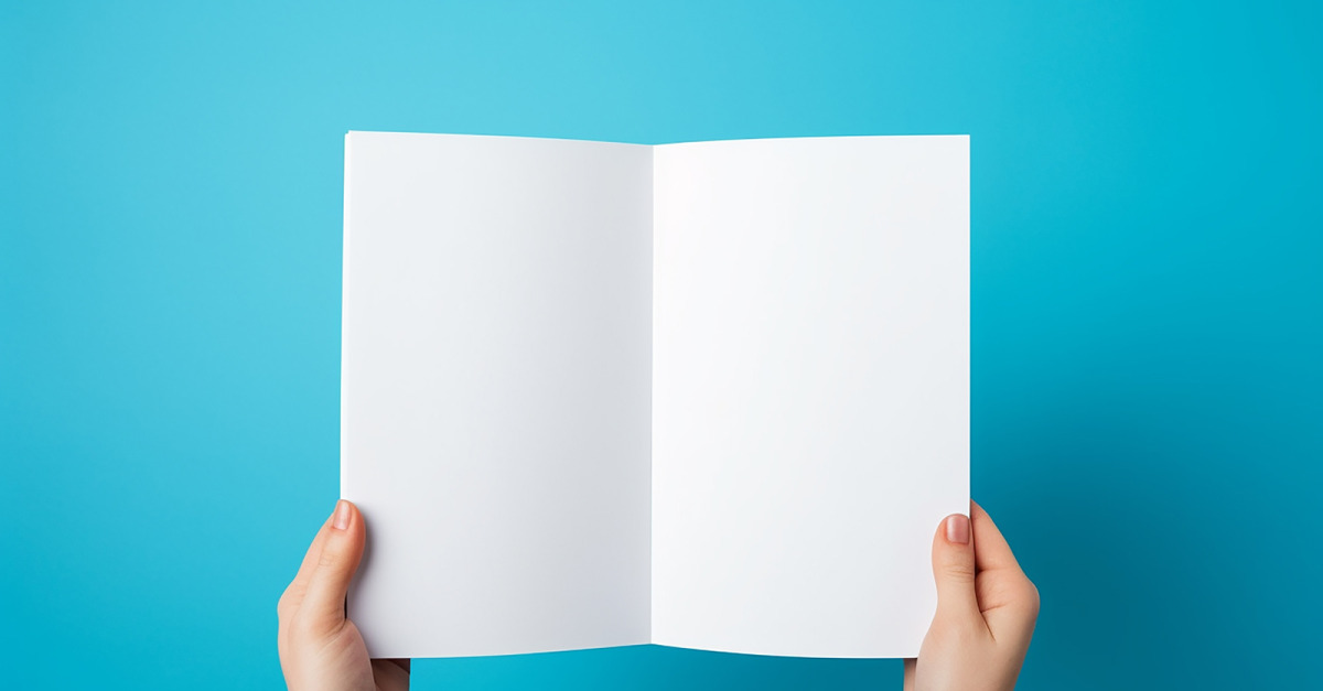 Hands holding a white folding flyer. - TemplateMonster